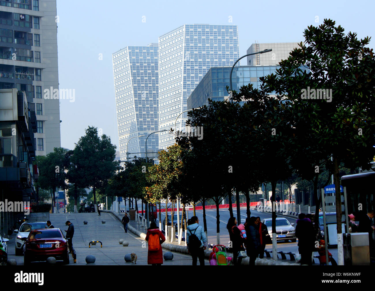 Local residents walk past the 101.3-meter-tall leaning buildings in ...