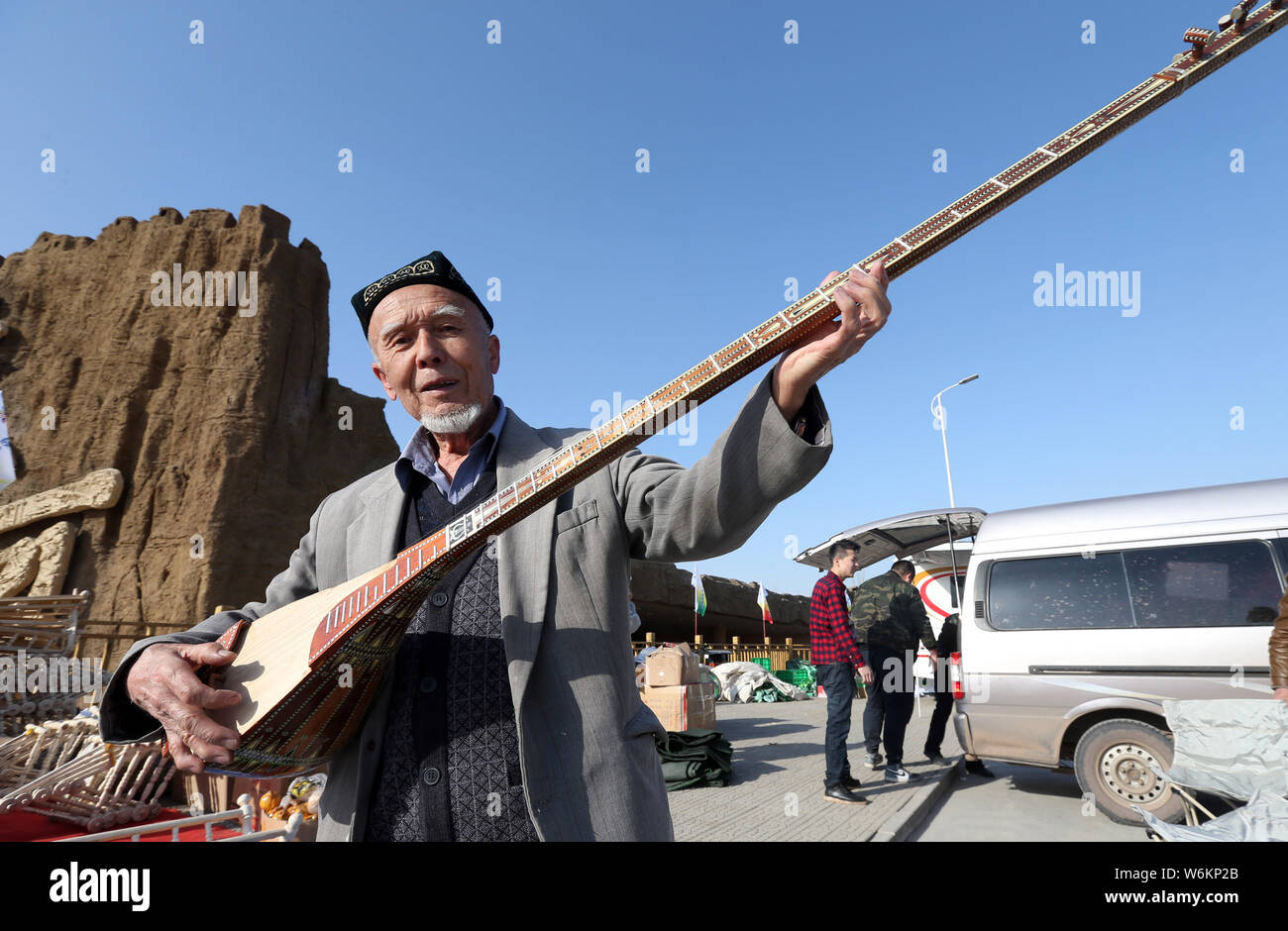 An elderly Chinese Uigur man plays an ethnic musical instrument during ...