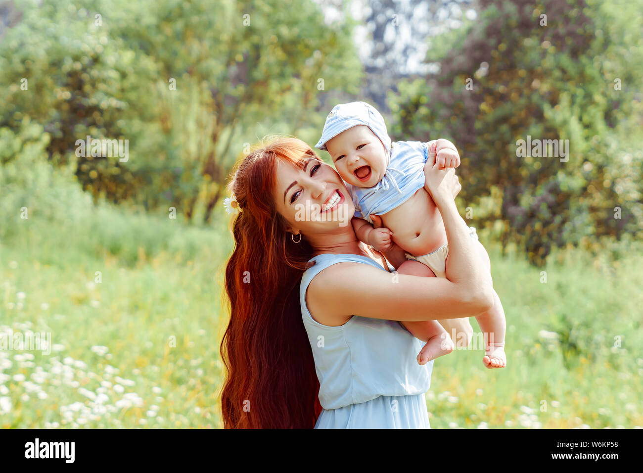 A young mother raised her baby in her arms Stock Photo - Alamy
