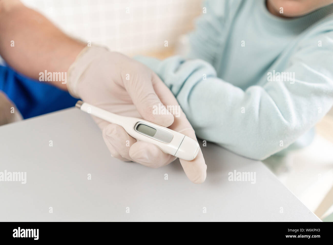 Male arm hold electronic thermometer showing high temperature ...