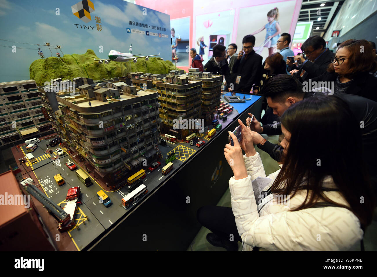 Visitors take photos of models of typical tenement buildings in Hong ...