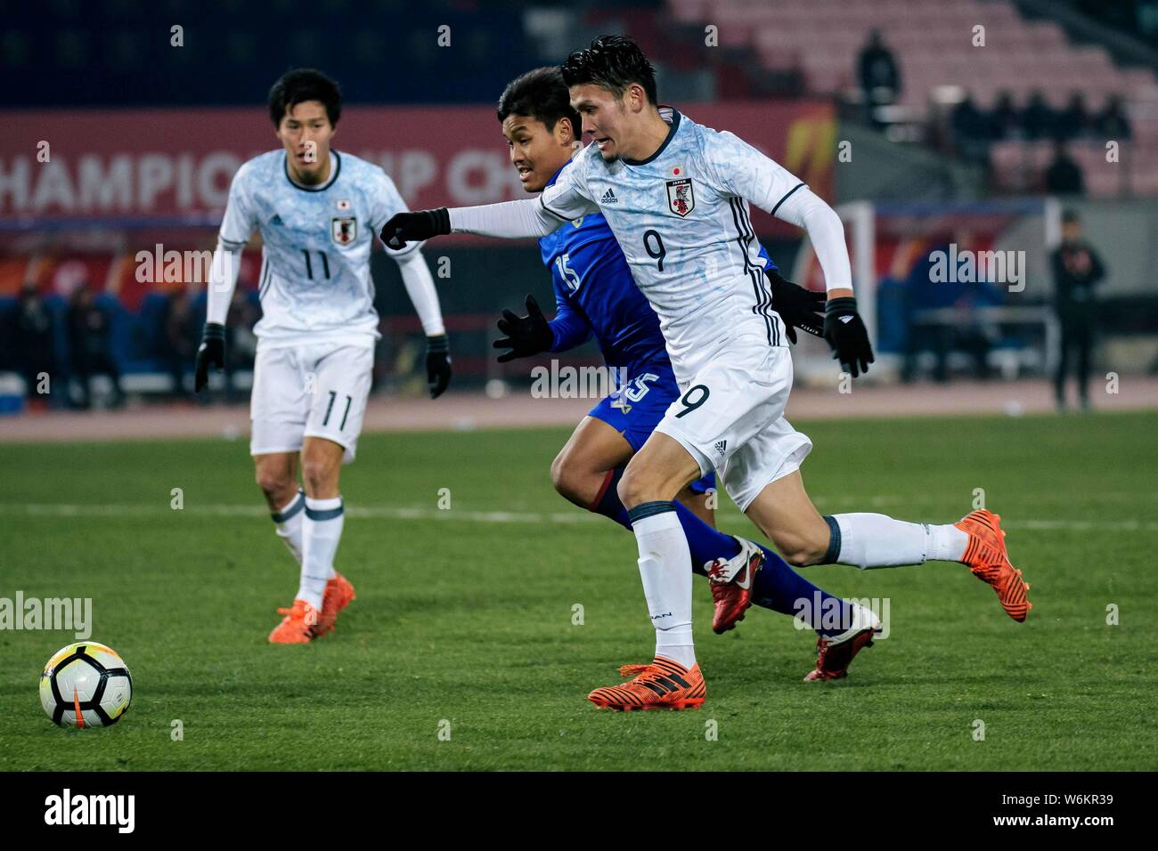 Kyosuke Tagawa, right, of Japan kicks the ball to make a pass against Saringkan Promsupa of ...