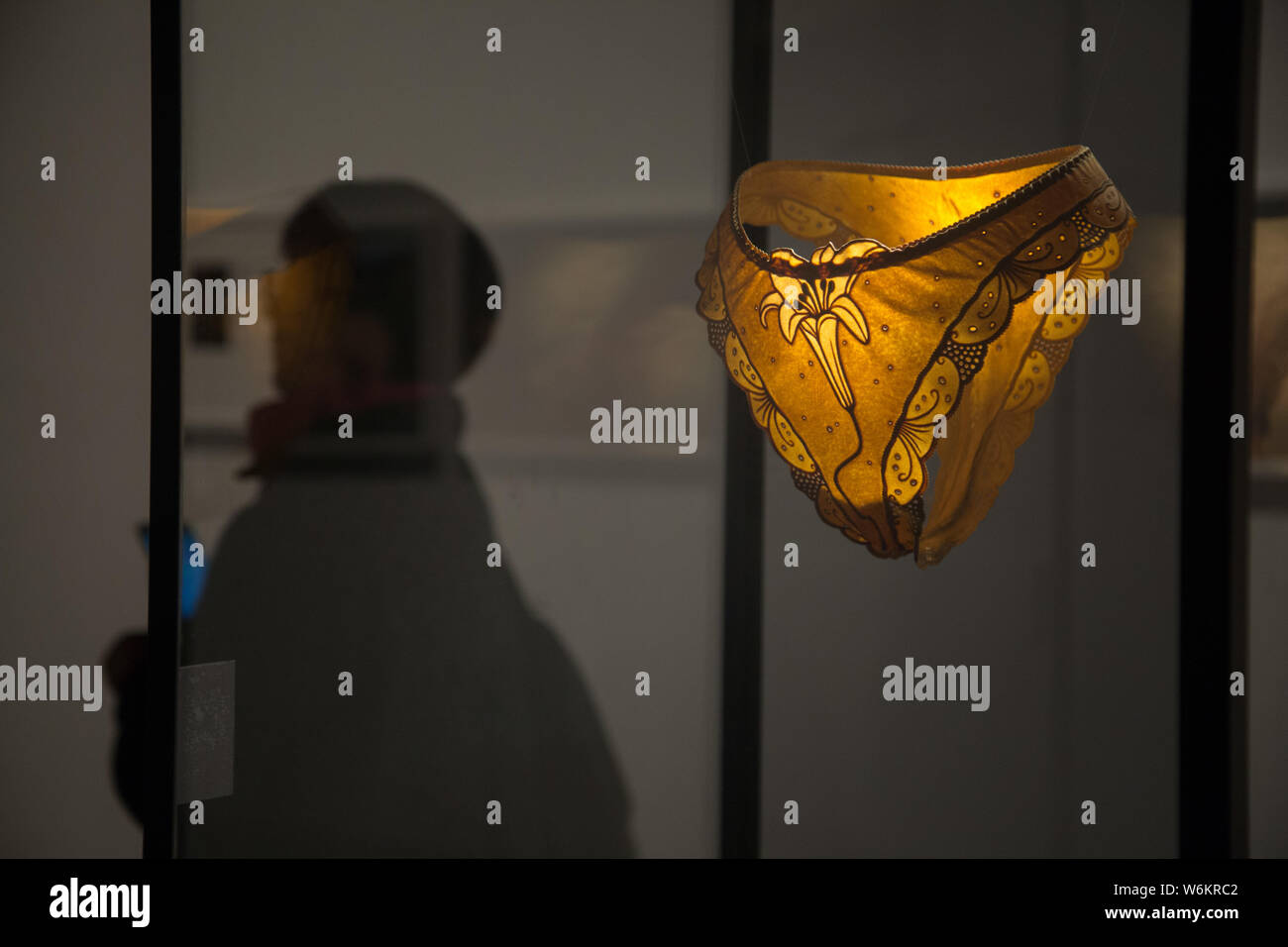 A visitor looks at the wood artwork "Woman Walking" created by ...