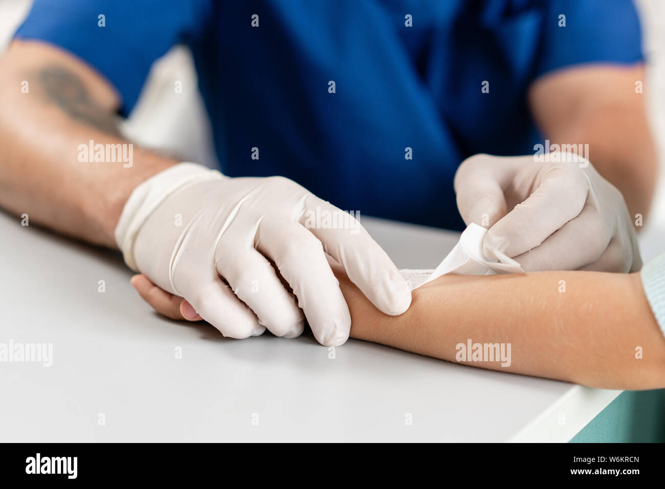 medical patch. Doctor in blue uniform make elastic bandaged around a ...