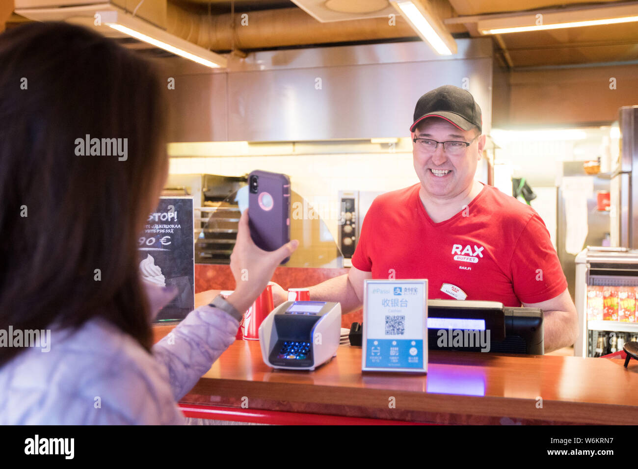 A Chinese customer shows her smartphone to an employee after scanning a ...