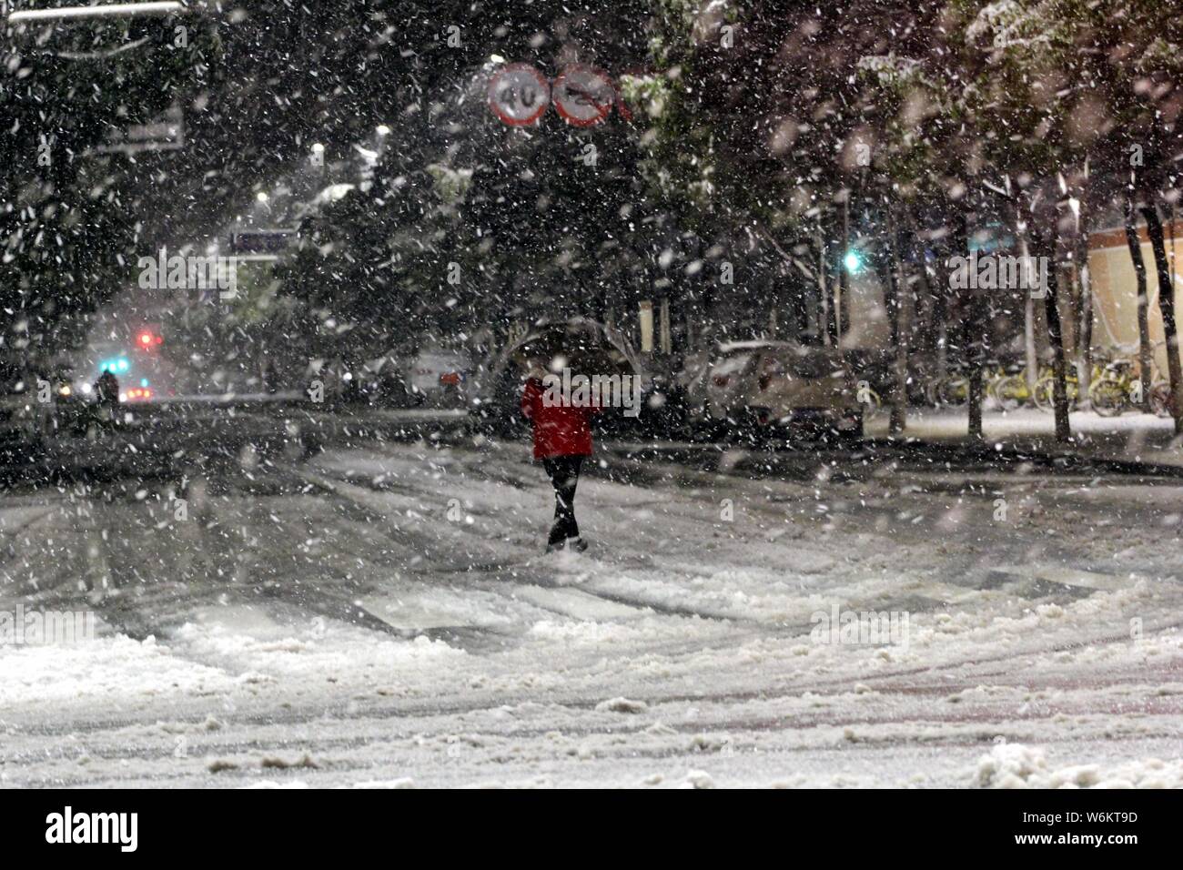 A pedestrian walks on the road in the snow in Nanjing city, east China ...