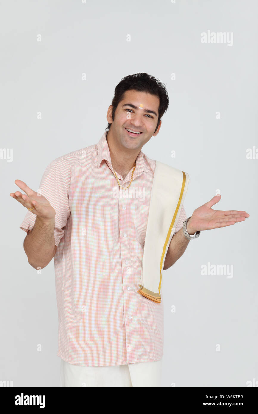 South Indian man smiling with his arm outstretched Stock Photo - Alamy