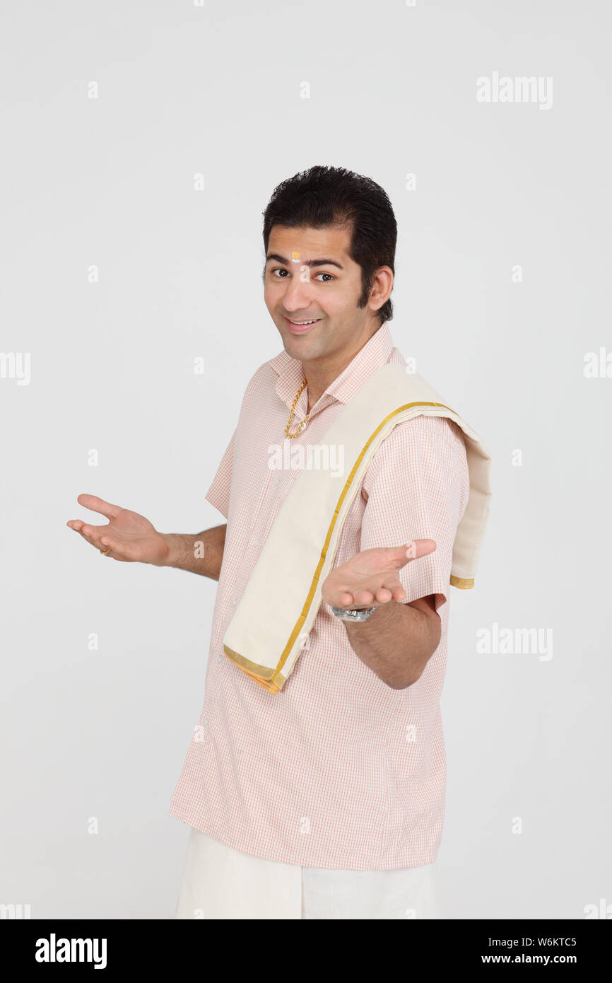 South Indian man smiling with his arm outstretched Stock Photo - Alamy