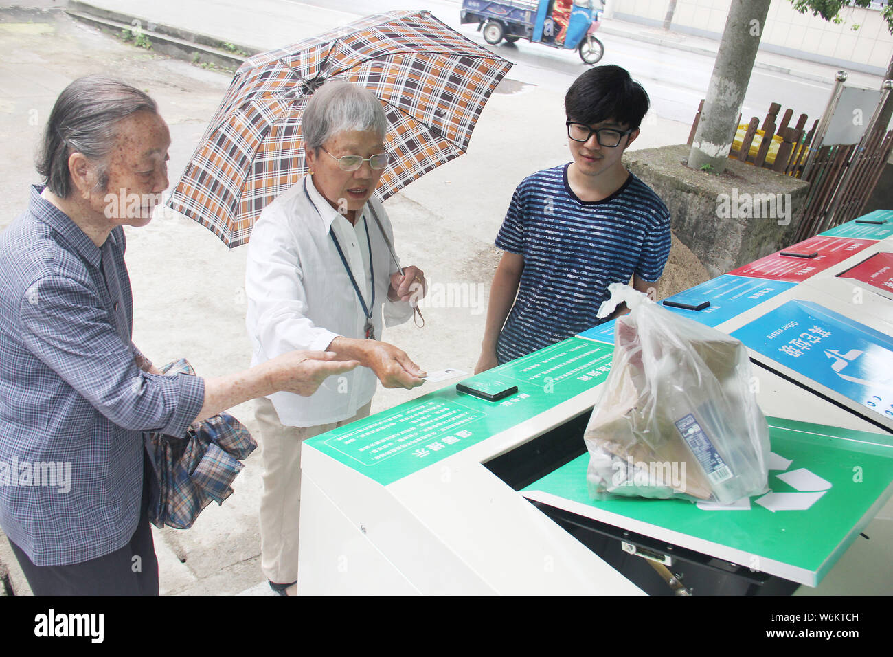 --FILE--A local resident swipes her ID card on an intelligent trash bin ...