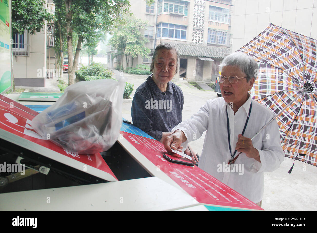 --FILE--A local resident swipes her ID card on an intelligent trash bin ...