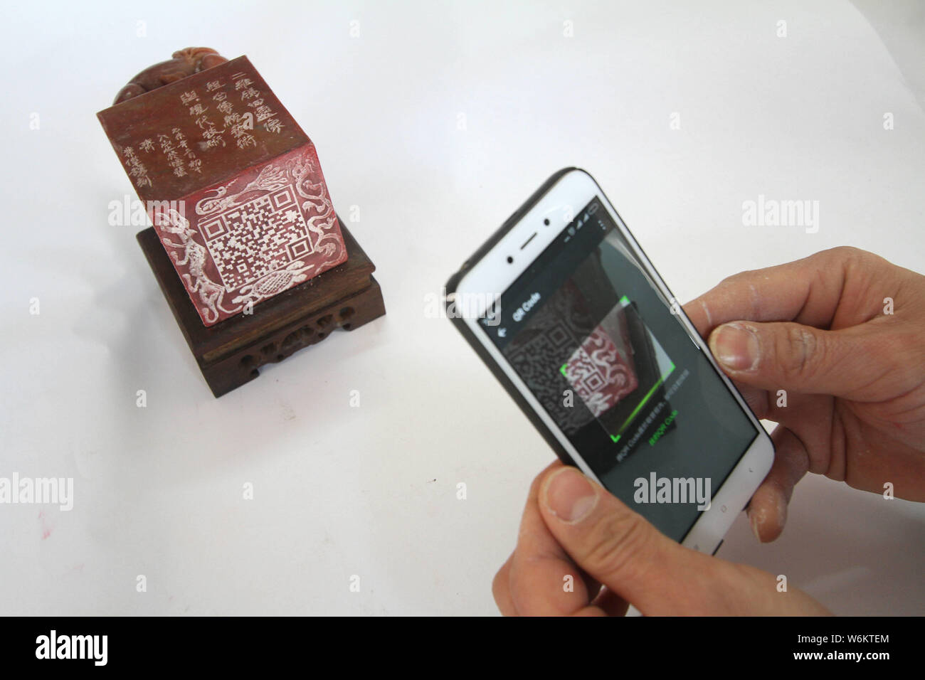 A citizen scans the QR code on the bottom of a seal made by Chinese ...