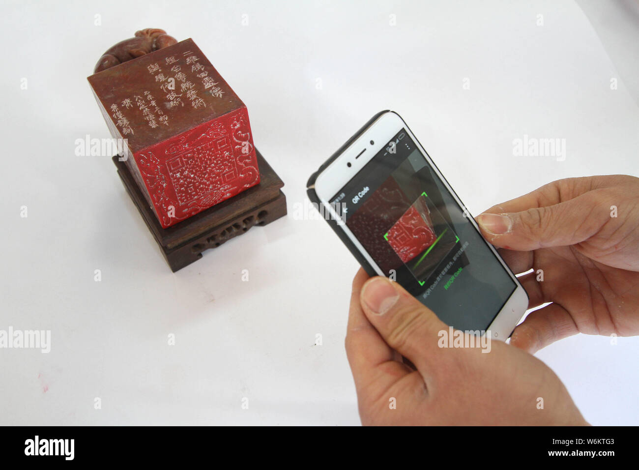 A citizen scans the QR code on the bottom of a seal made by Chinese ...