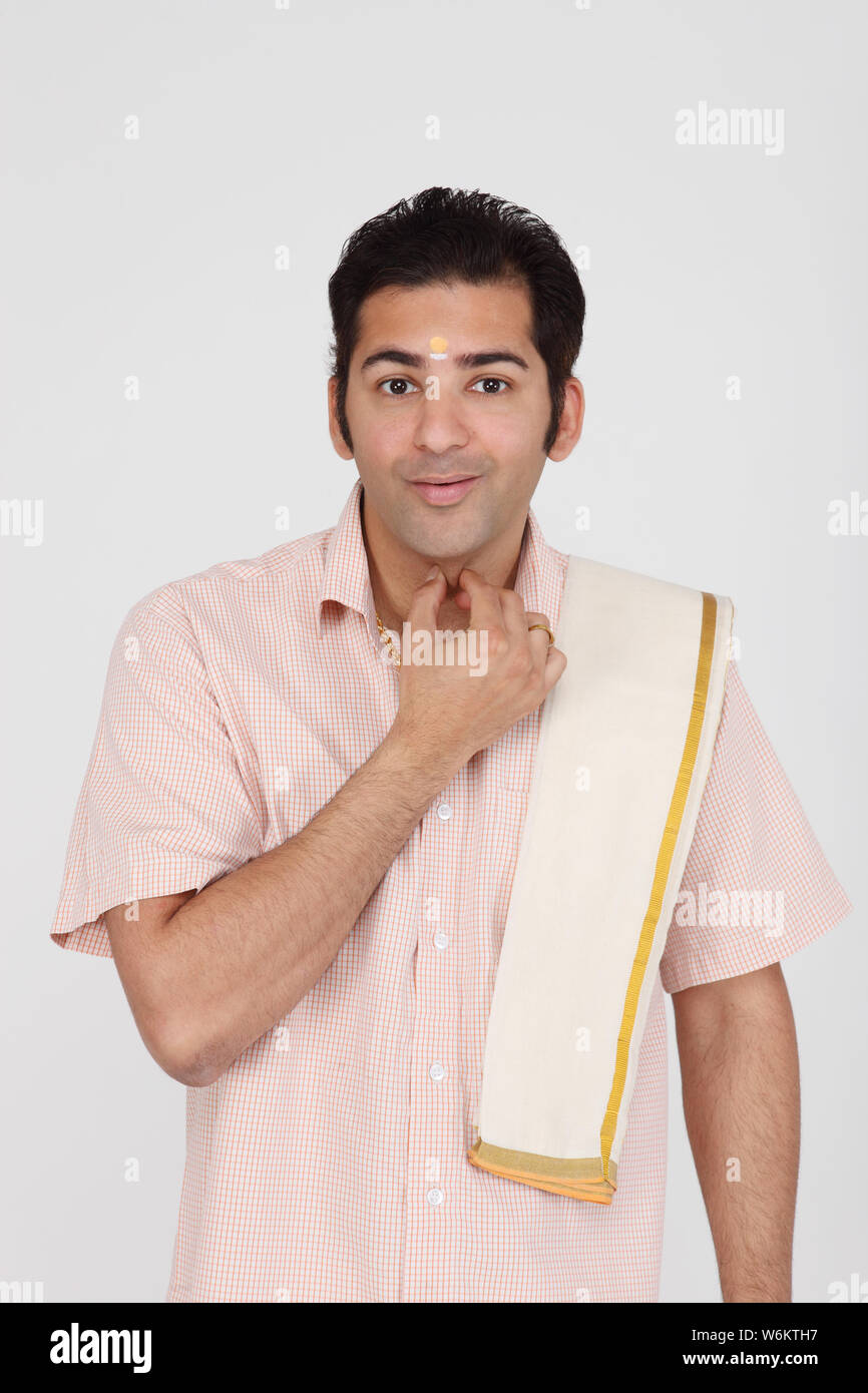 South Indian man swearing with hand on neck Stock Photo - Alamy