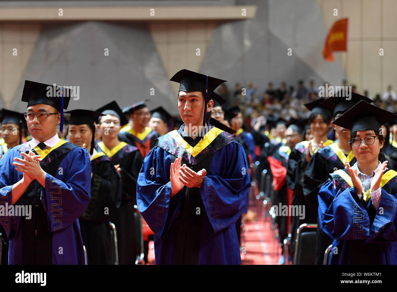 --FILE--Chinese graduates dressed in academic gowns attend a graduation ...