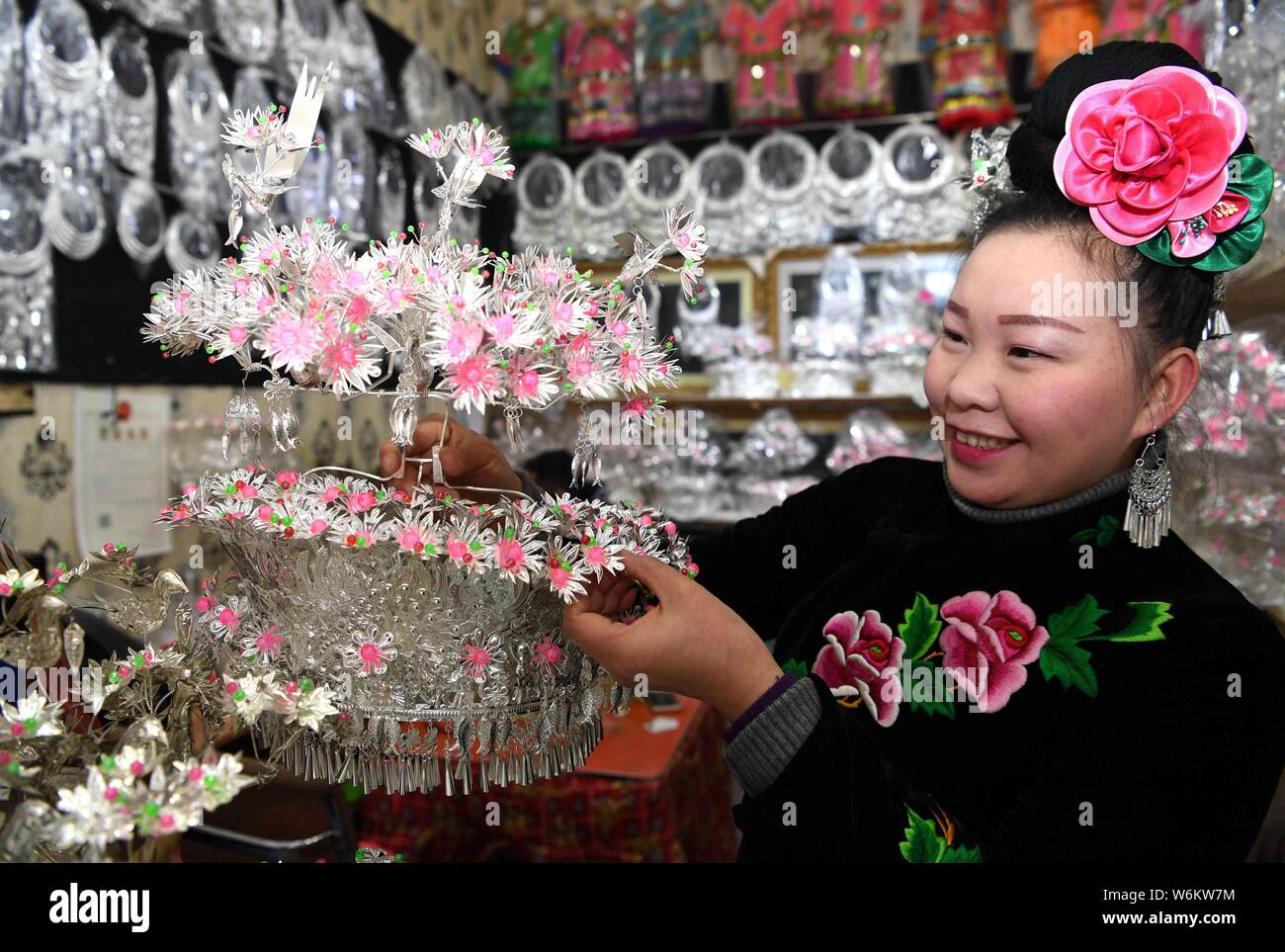 A vendor shows a traditional silver-decorated headwear of Chinese ...