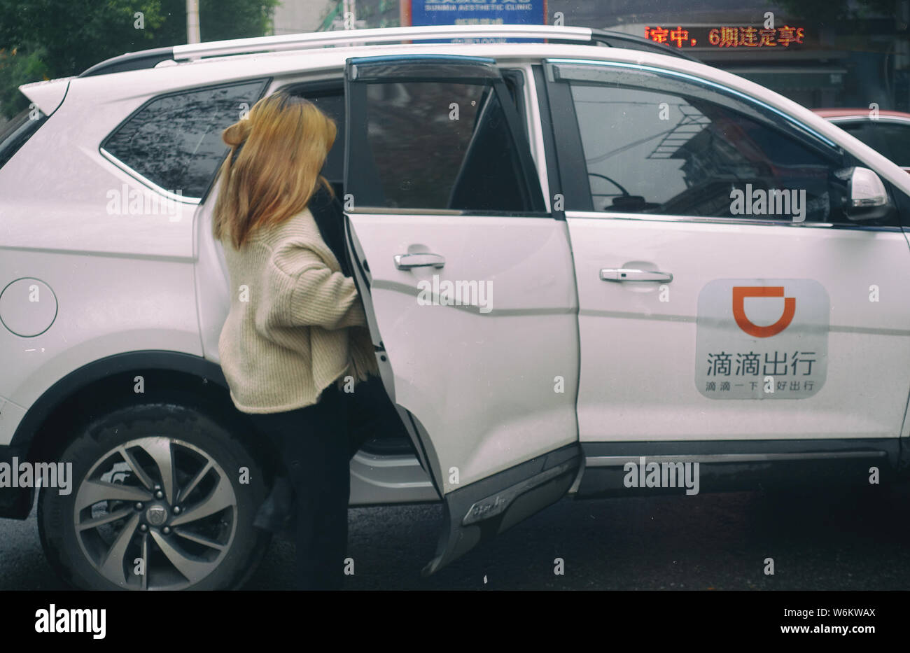 --FILE--A cyclist rides past a customized car of Chinese taxi-hailing ...