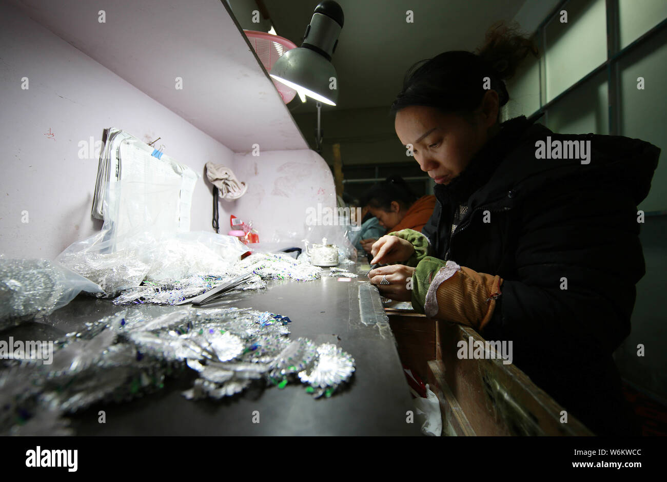 A Chinese craftsman makes a silver decoration for the upcoming Spring ...