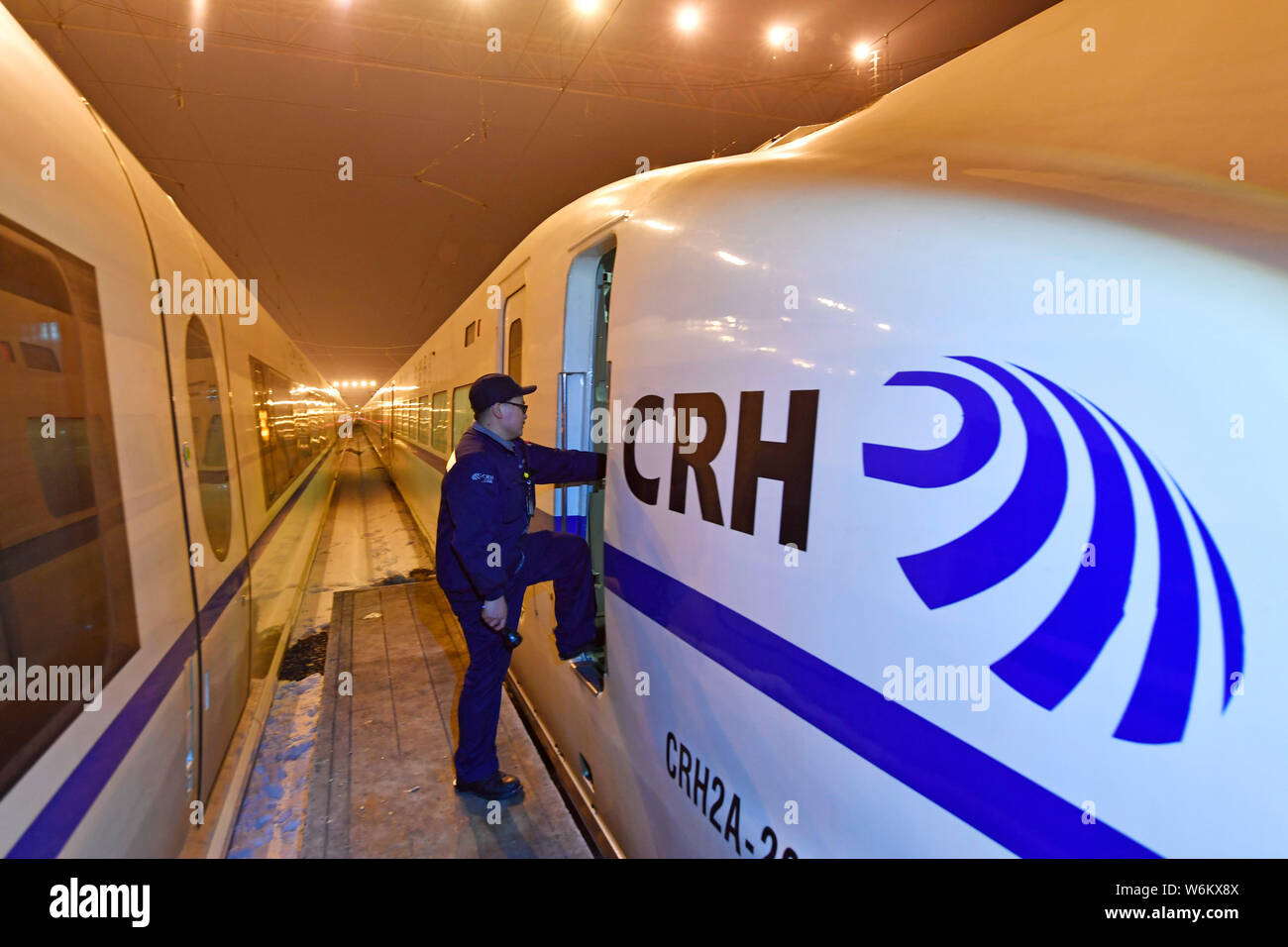 Chinese workers check a CRH (China Railway High-speed) bullet train for ...