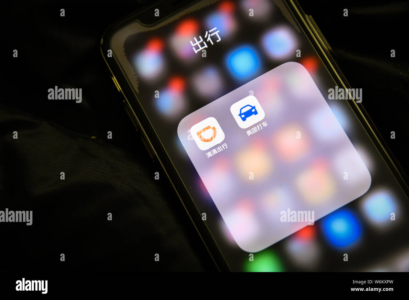 A mobile phone user shows the icons of the taxi-hailing and car-service ...