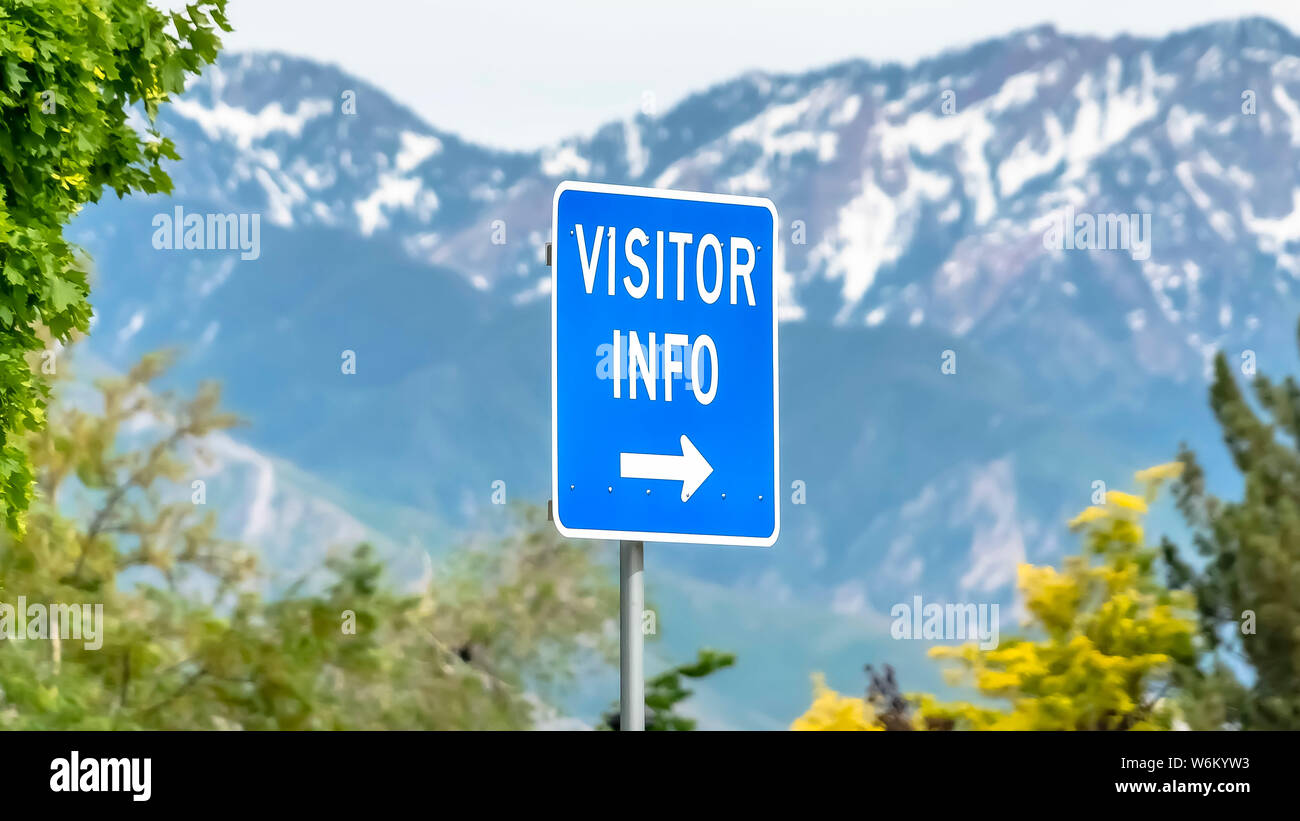 Panorama Close up of a Visitor Info sign with trees snowy mountain and ...