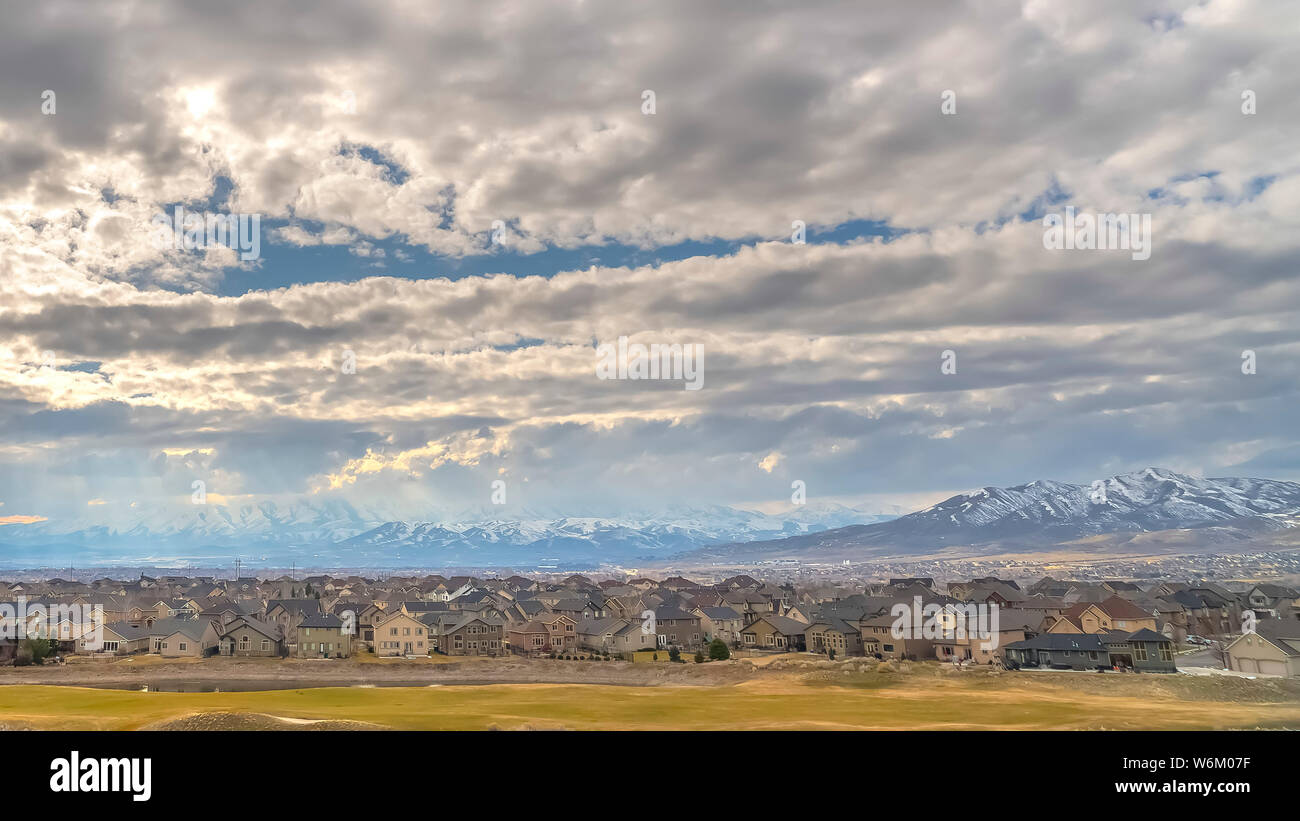Panorama Panoramic view of cloud filled blue sky over houses on a vast ...