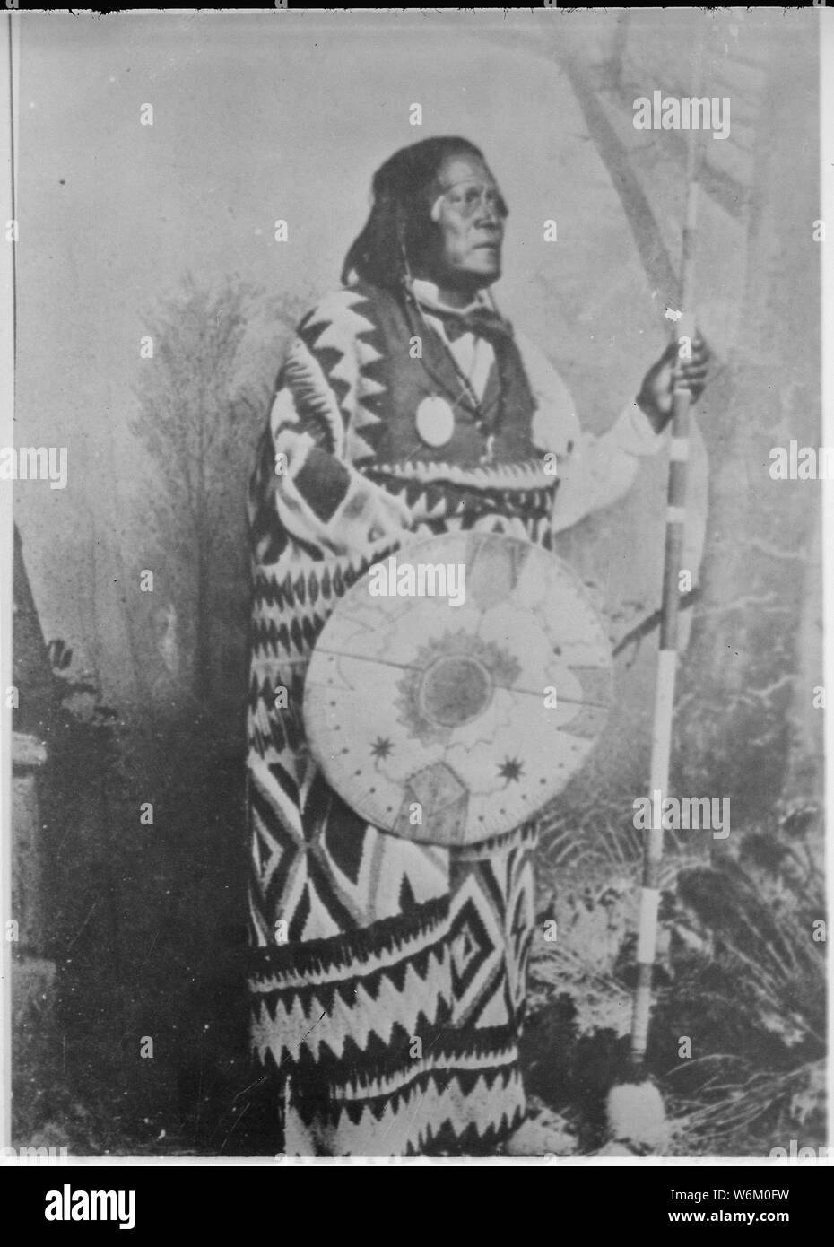 San Juan, a Mescalero Apache chief; standing, full-length, holding a ...