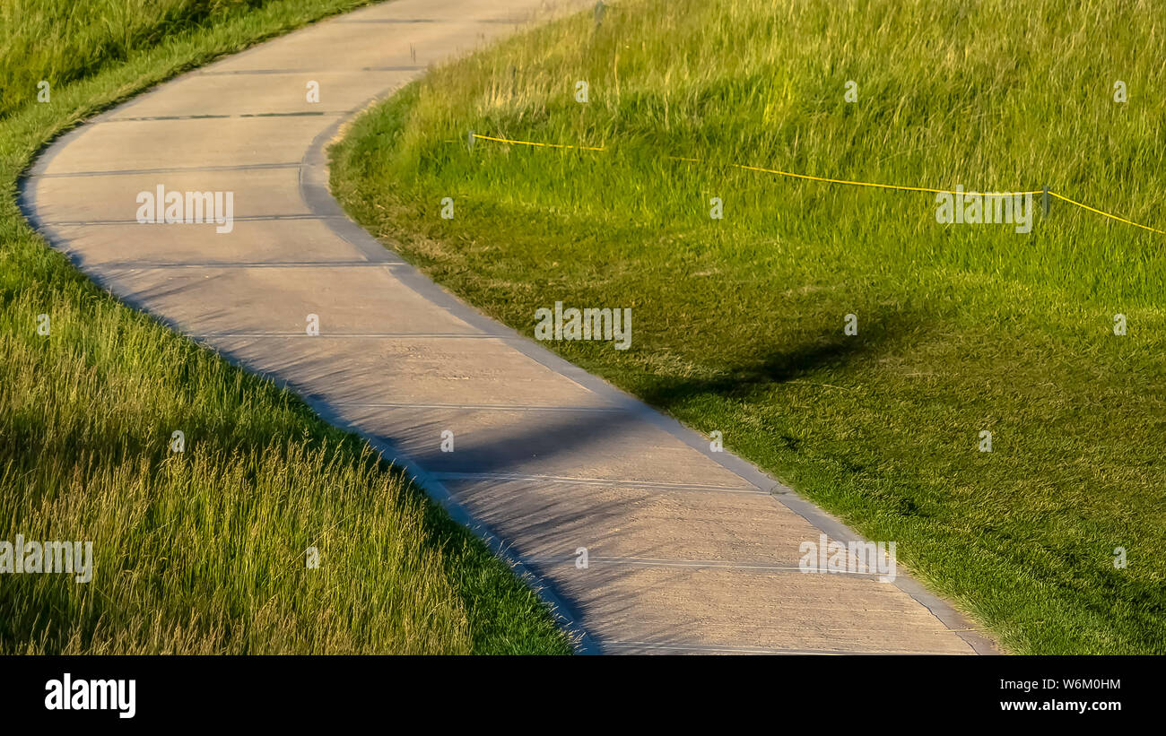 frame Pathway that winds through a grassy terrain with houses in the ...