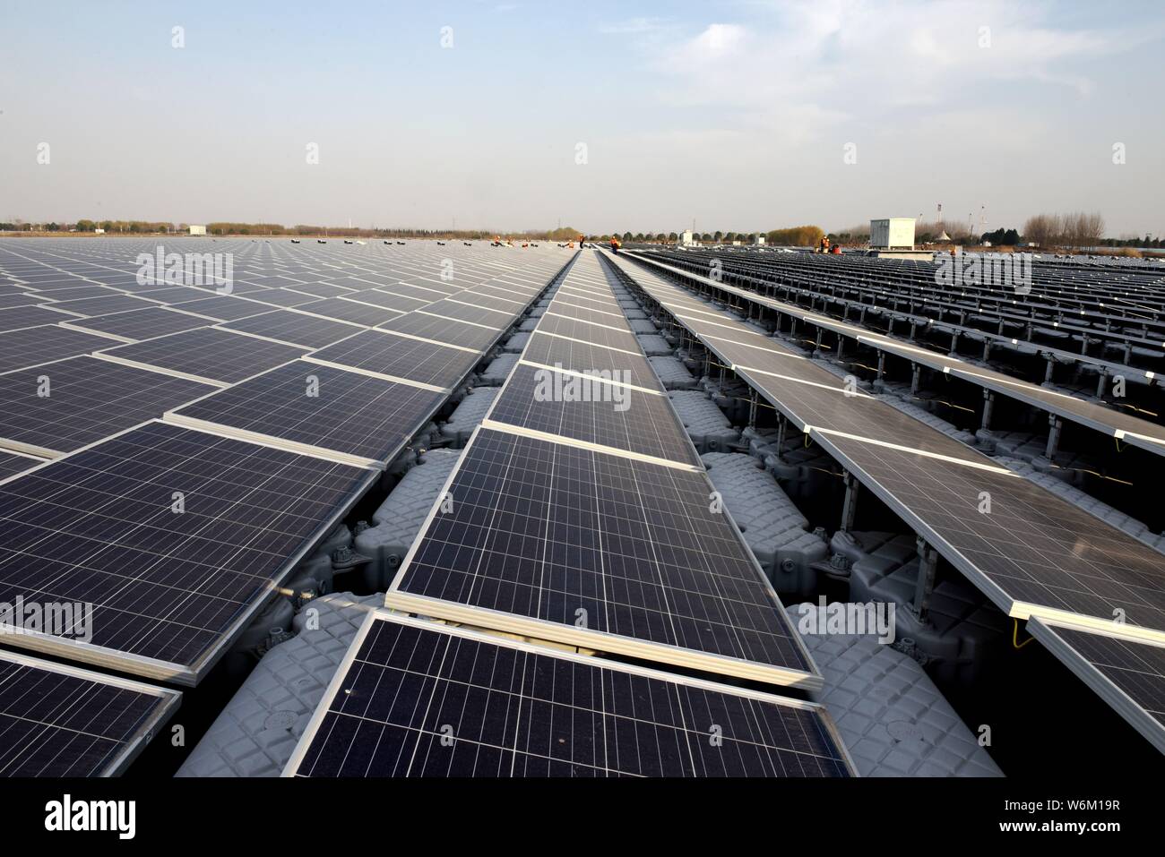 --FILE--Chinese workers install solar panels at a photovoltaic power ...