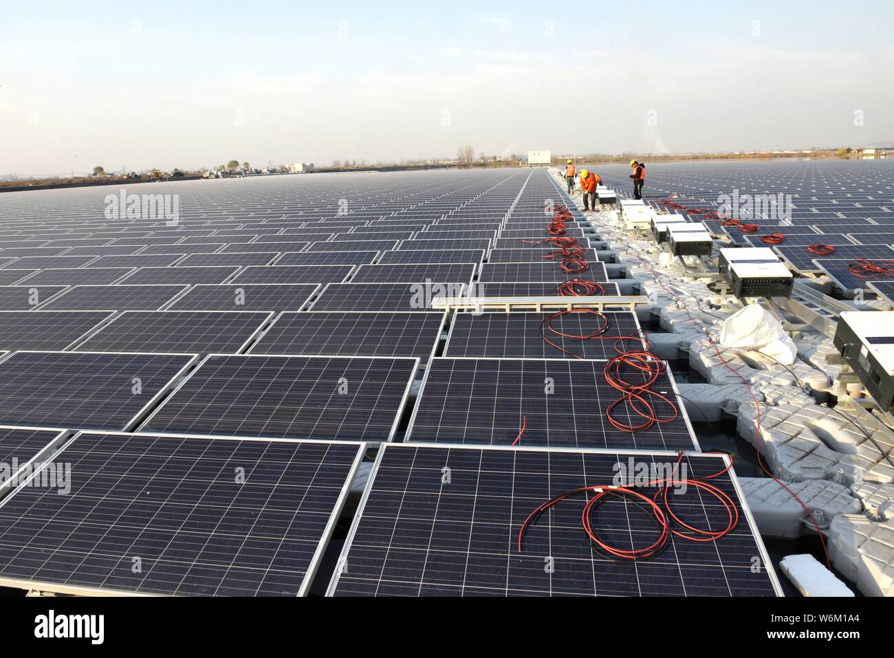 --FILE--Chinese workers install solar panels at a photovoltaic power ...