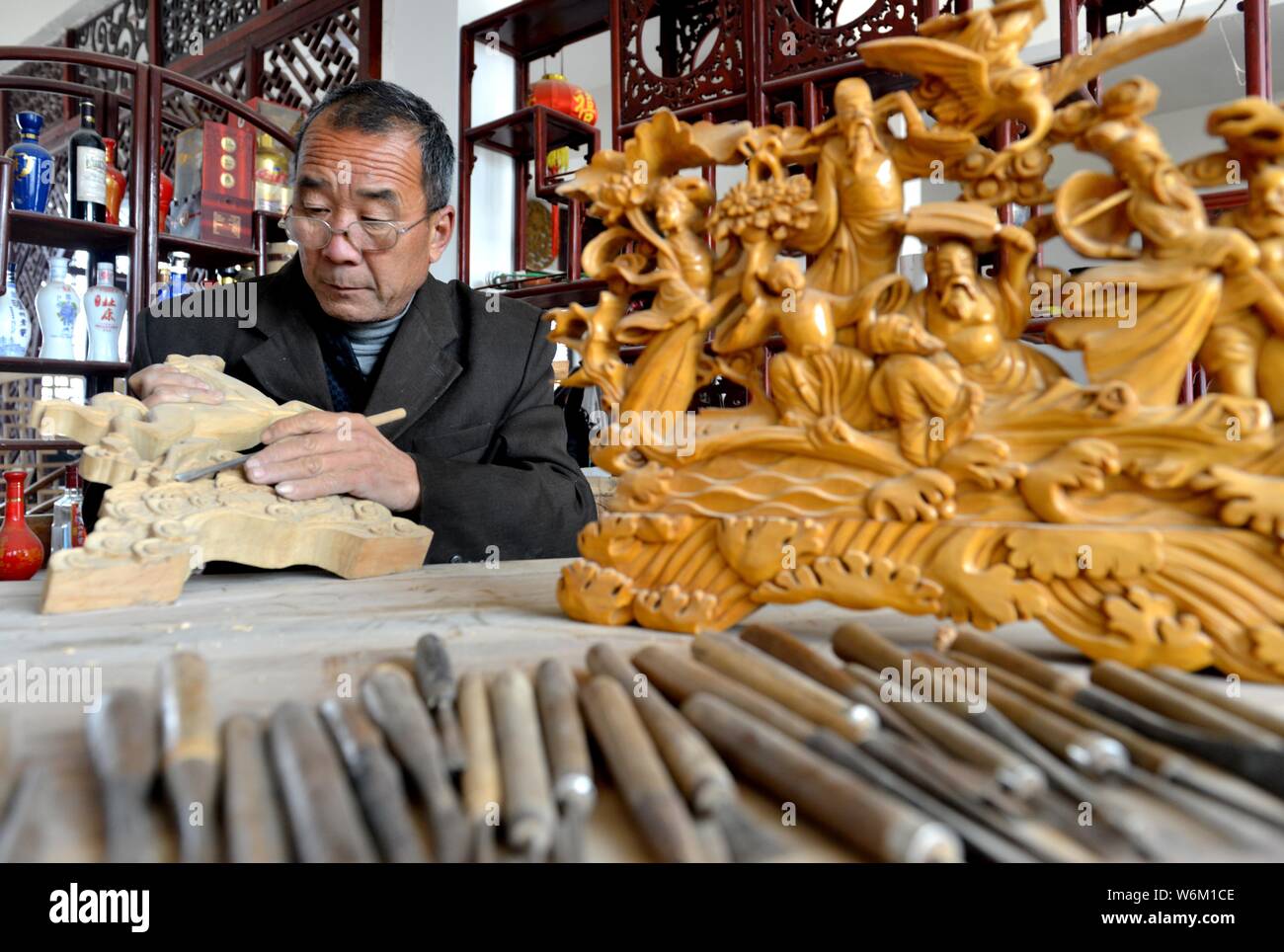 57-year-old Chinese craftsman Wang Sijun craves a wooden figure of a ...