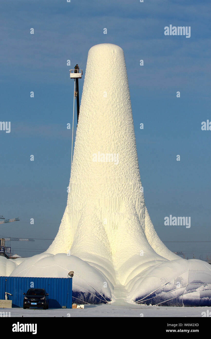 A Chinese worker labors at the world's tallest ice tower, which is 30 ...