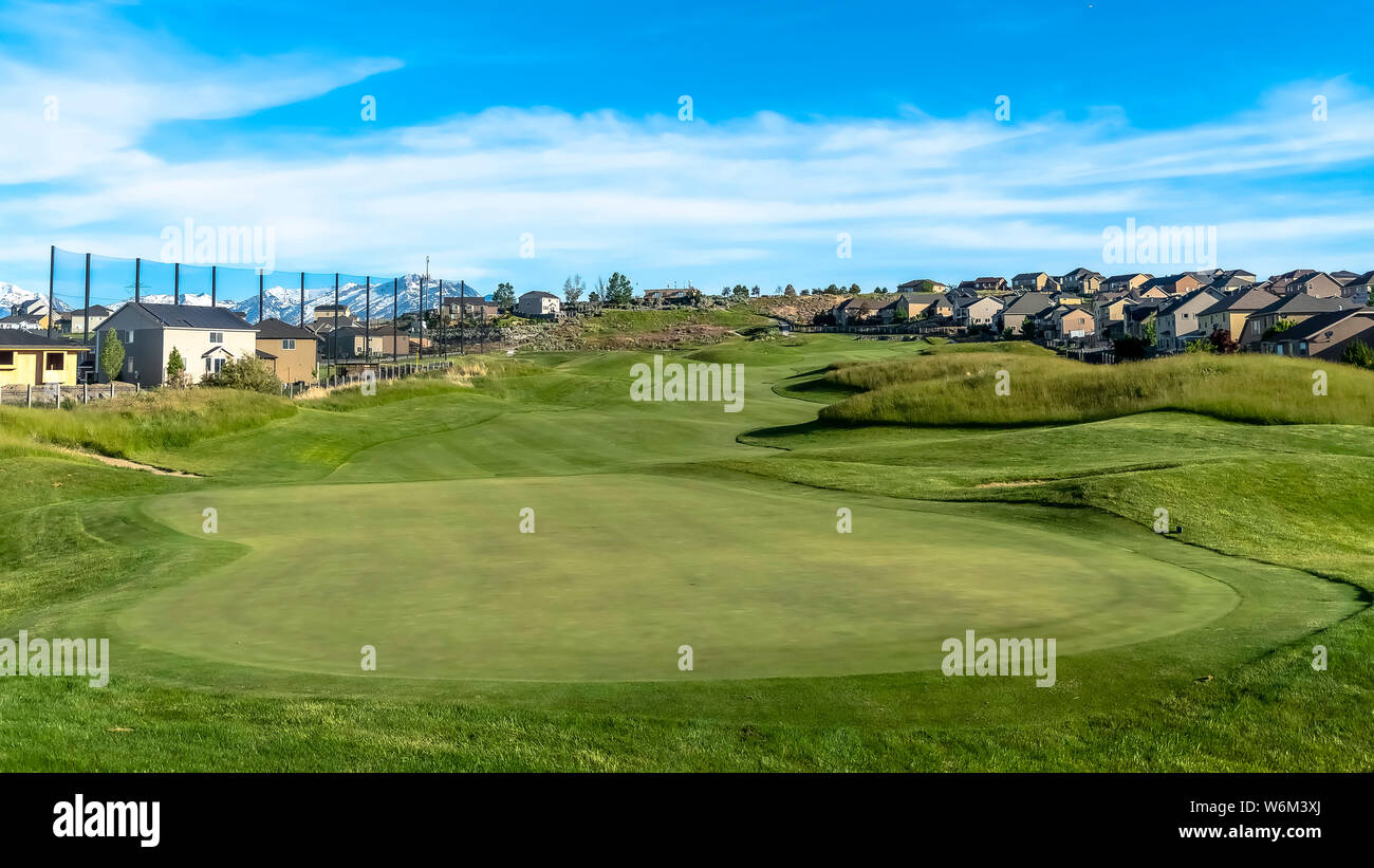 Panorama Golf course and homes under blue sky with clouds viewed on a ...