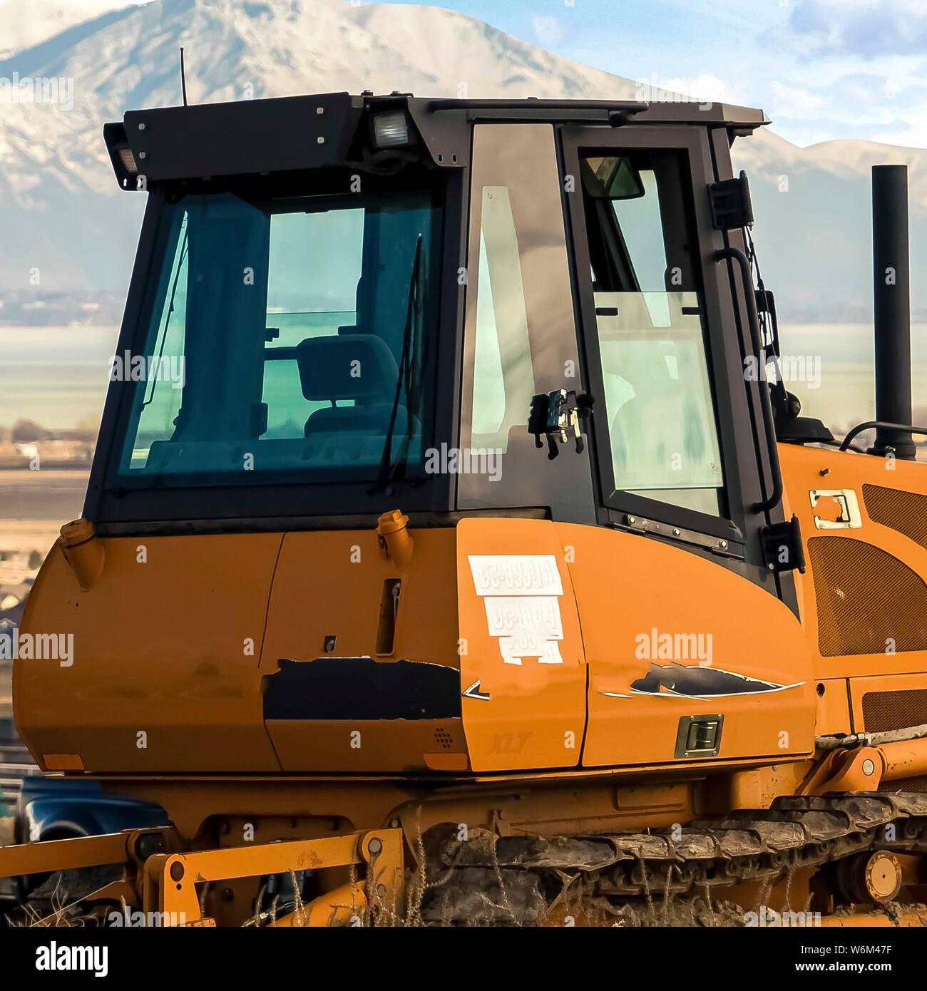 Square Yellow loader on a hill overlooking houses on a residential area ...