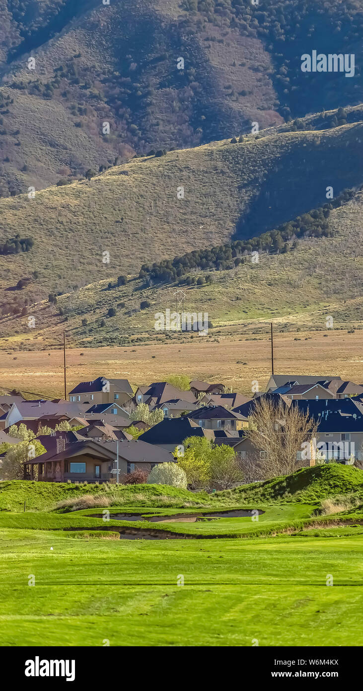 Vertical Residential area near the base of a towering mountain viewed ...