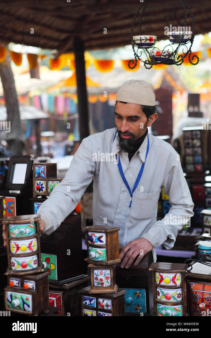 Shopkeeper arranging showpieces at Surajkund Crafts Mela, Surajkund ...