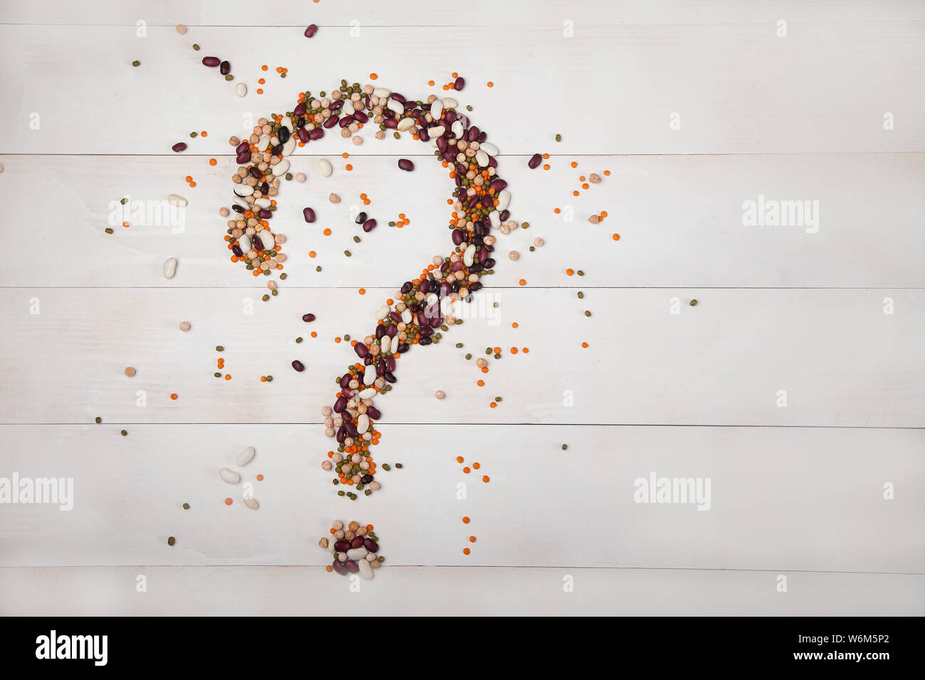 Beans, lentils, peas laid out on a white wooden background in the form ...