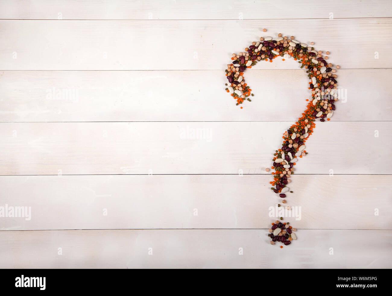 Beans, lentils, peas laid out on a white wooden background in the form ...