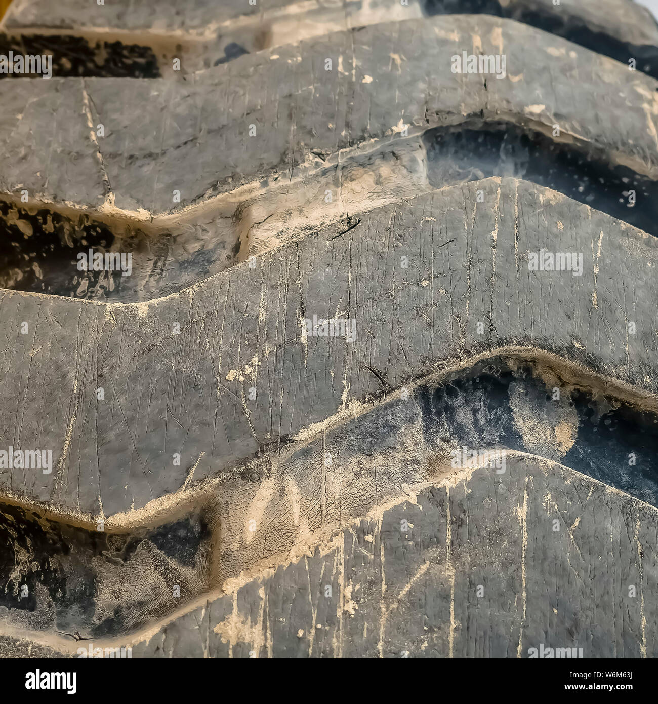 Square frame Thick black rubber tire of a yellow construction equipment ...