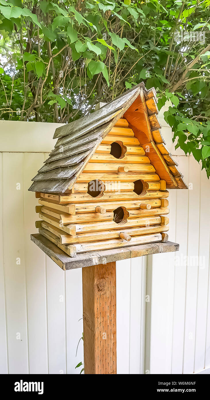 Vertical Close up of wooden birdhouse with several entrance holes at ...