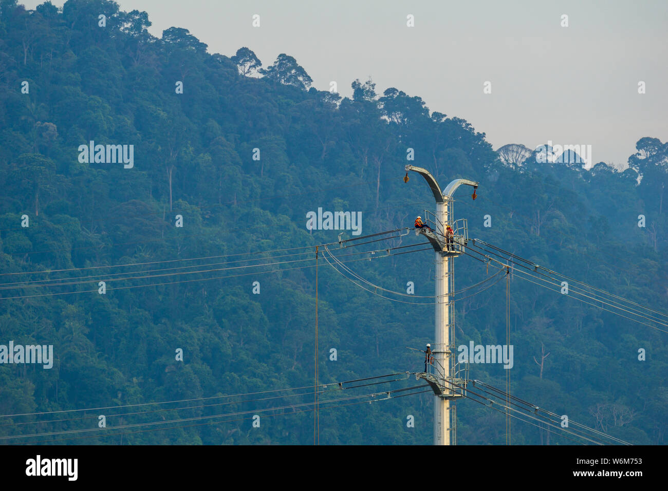 Workers working on power pole at sub urban area of Kuala Lumpur ...