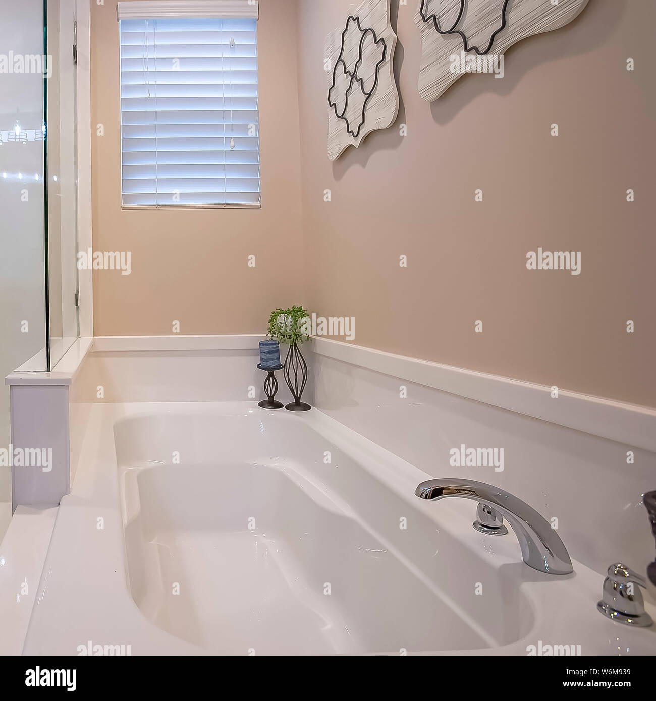 Square Glass walled shower stall and shiny bathtub inside the bathroom ...