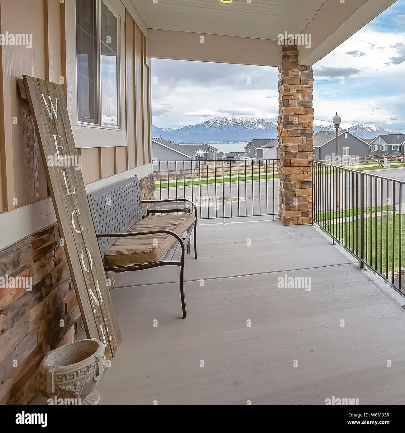 Square frame Porch overlooking yard road homes lake and mountain under ...