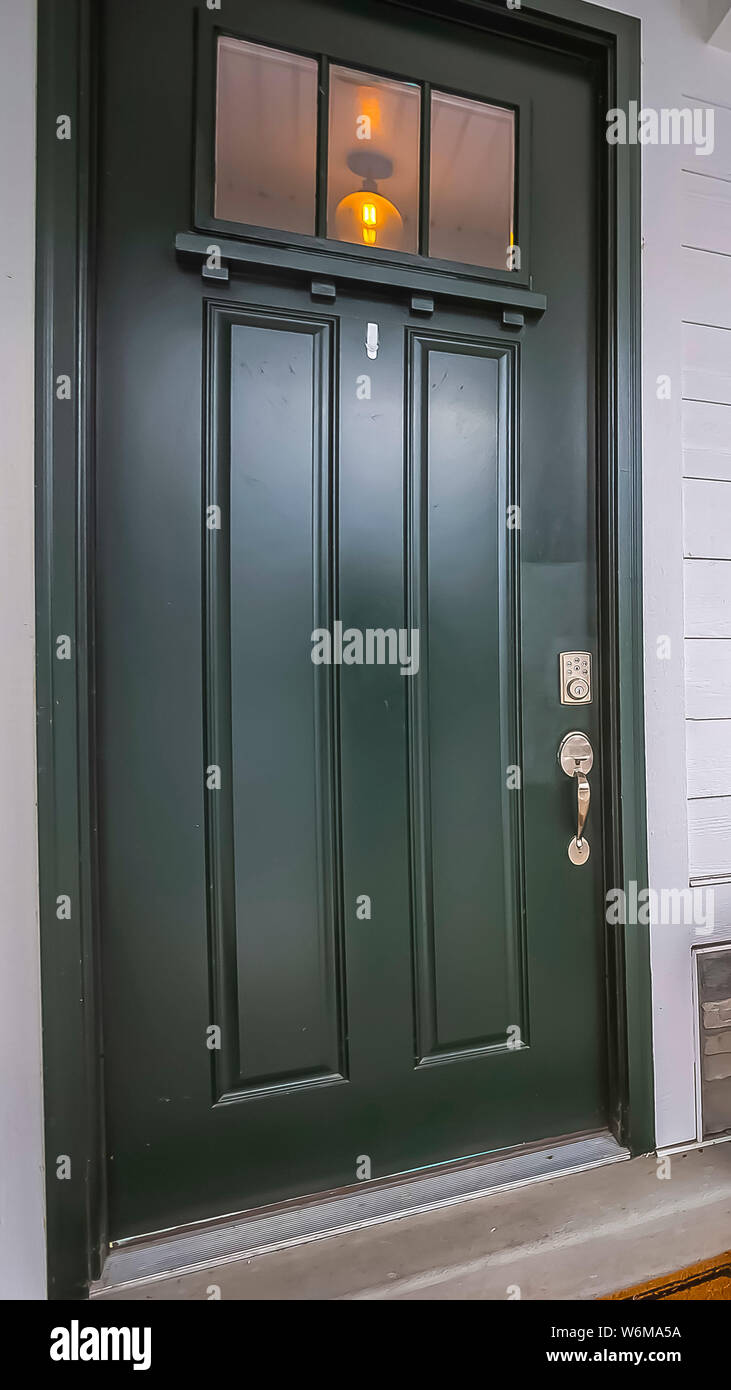 Vertical frame Home facade with glass paned front door and furniture on ...