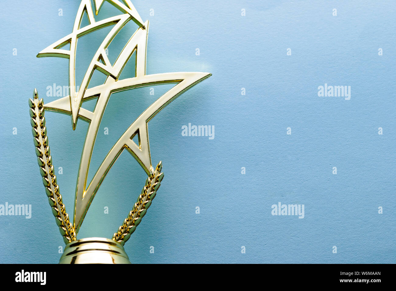 Gold star trophy for a competition or championship winner over a grey ...