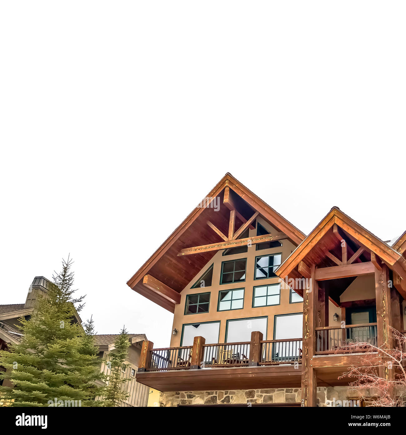 Square Home facade with wood accents balcony and shiny windows against ...