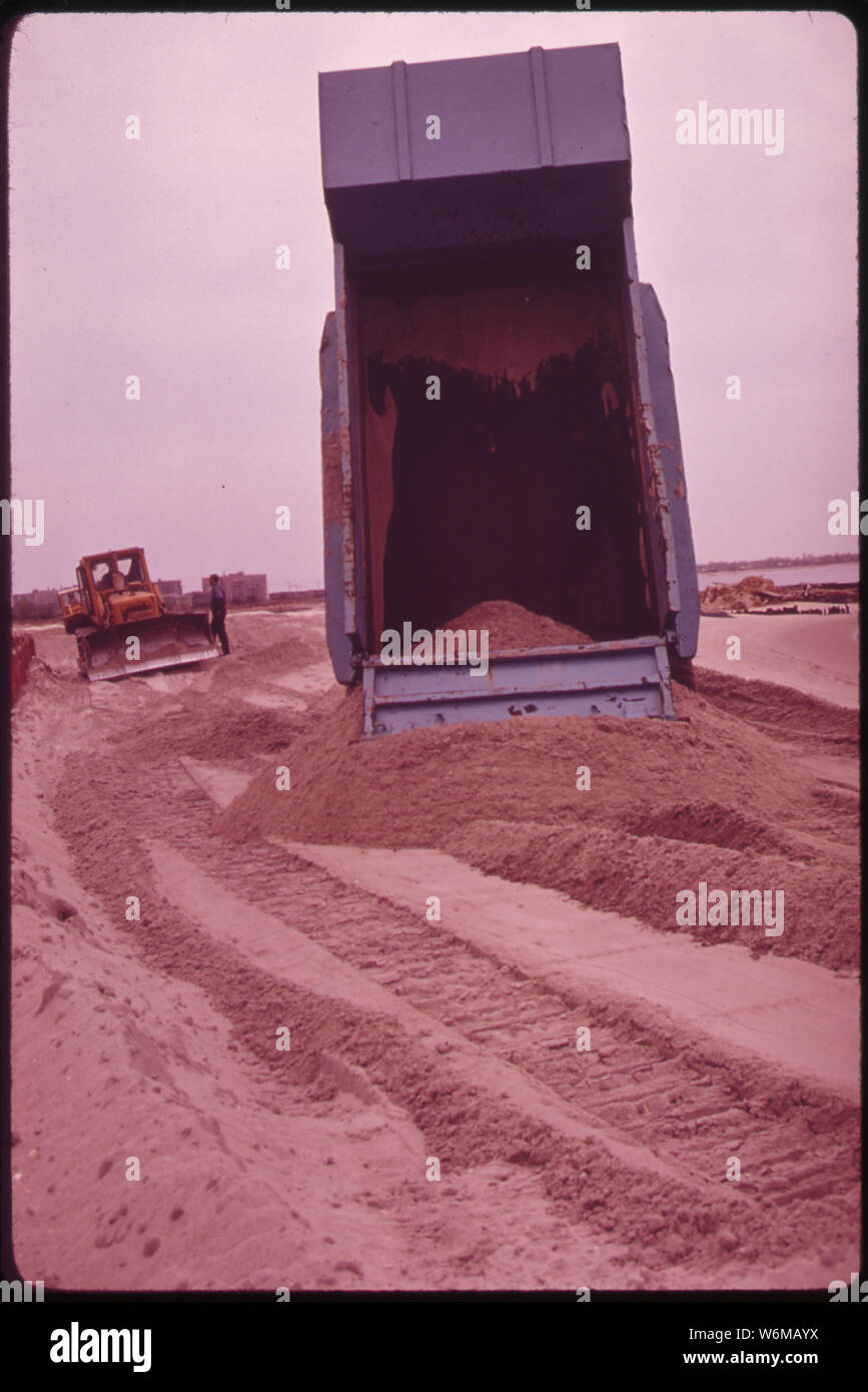 TRACTORS DUMP SAND AT BREEZY POINT TO PREVENT SHORE EROSION AND PROTECT ...