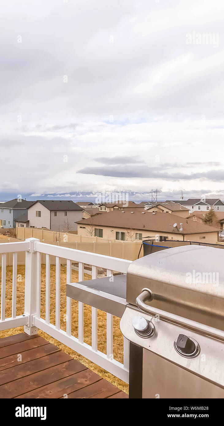 Vertical frame Brown wooden deck with white railing overlooking yard ...