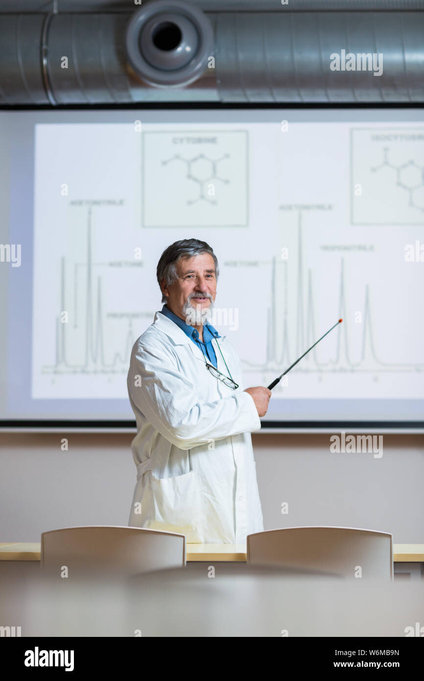 Senior chemistry professor giving a lecture in front of classroom full ...
