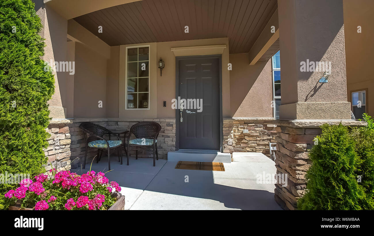 Panorama Porch chairs by the gray wooden front door and window of a ...