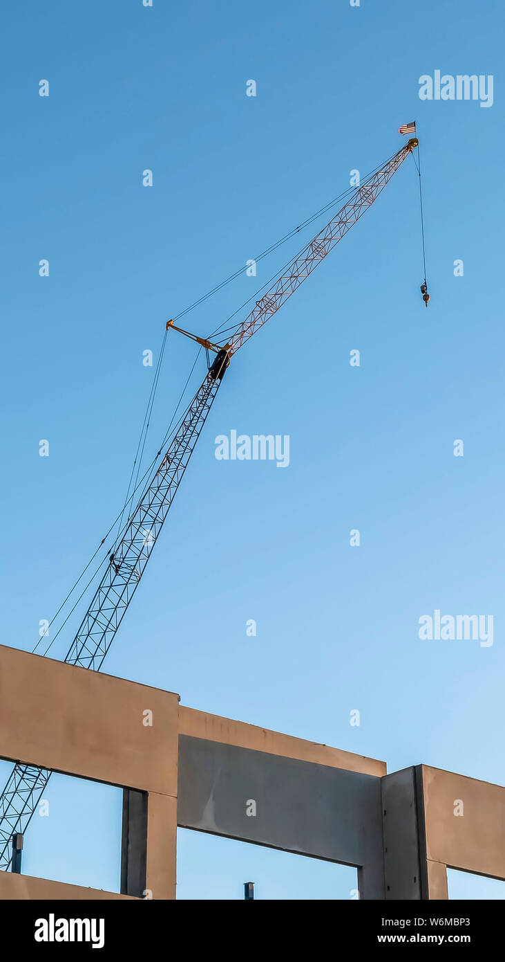 Vertical frame Unfinished building exterior and construction crane with ...